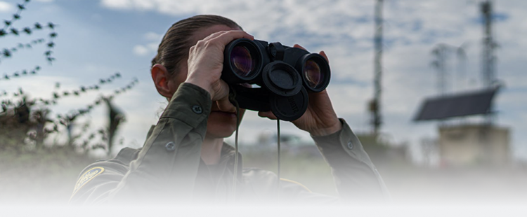 Border Patrol Agent looking through binoculars
